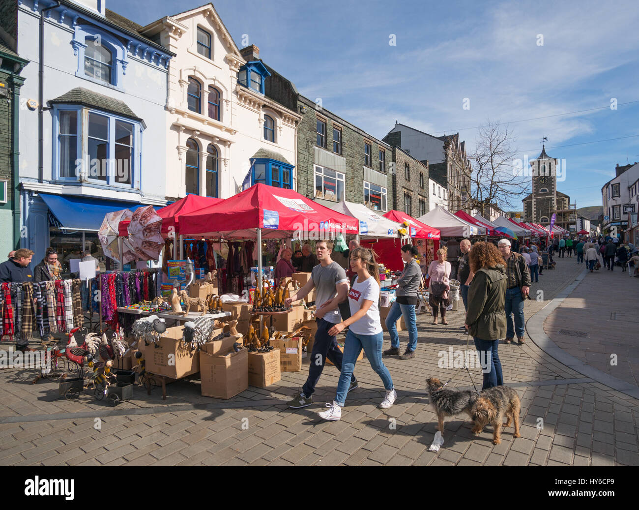 A young couple walk through Keswick street market, Cumbria, England, UK ...
