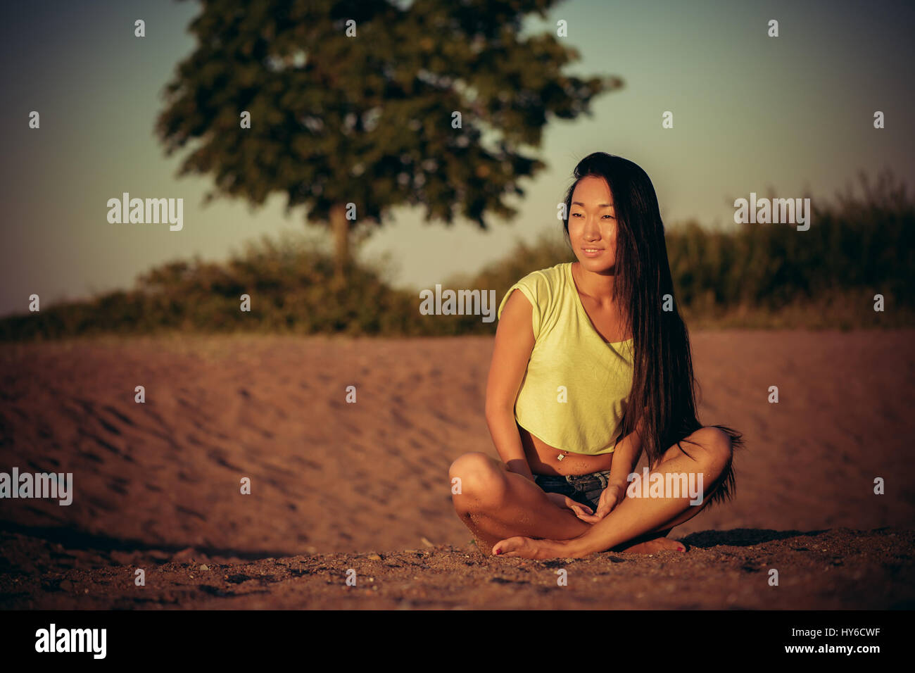 Woman sitting on the sand Stock Photo - Alamy