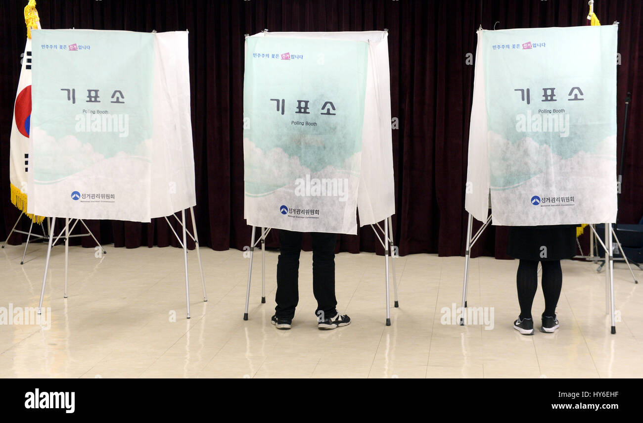 Hands holding a stamp casting a vote into the ballot box during ...