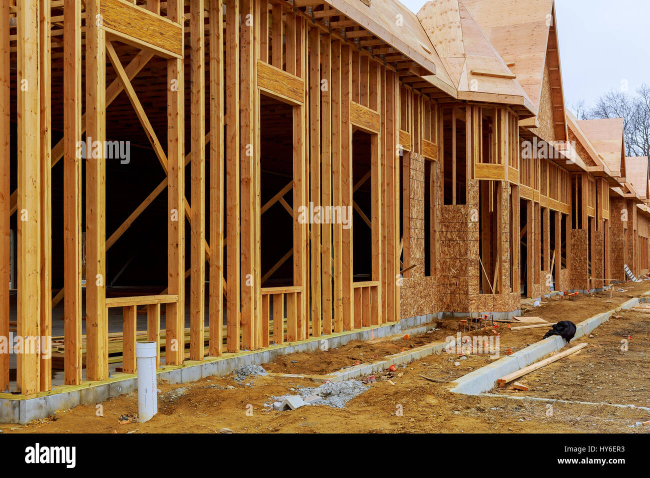 New residential construction home framing against a blue sky and sun ...