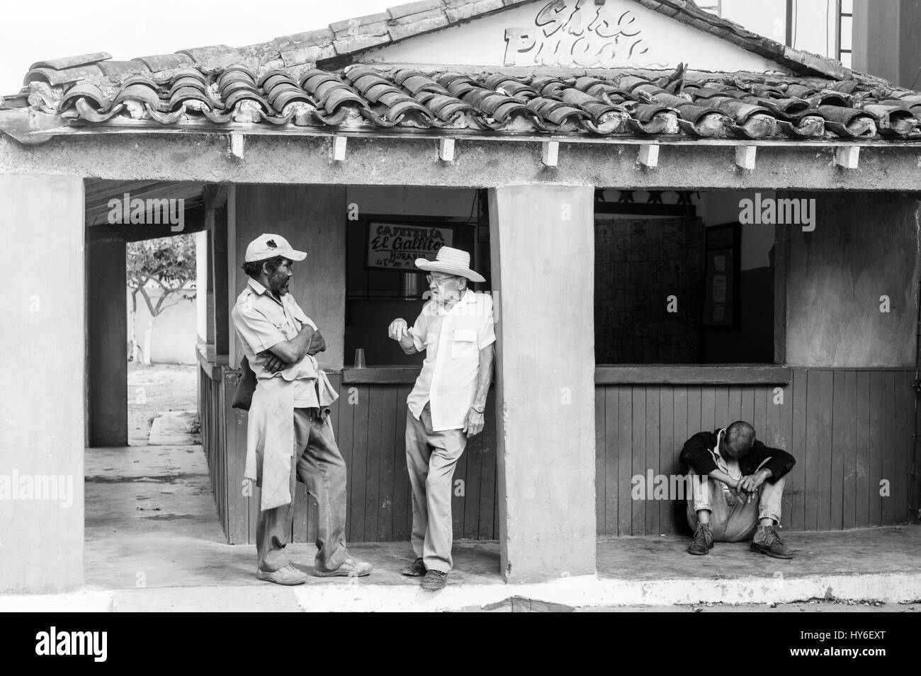 Two Cuban men talking on the porch of a corner store in Vinales, Cuba ...