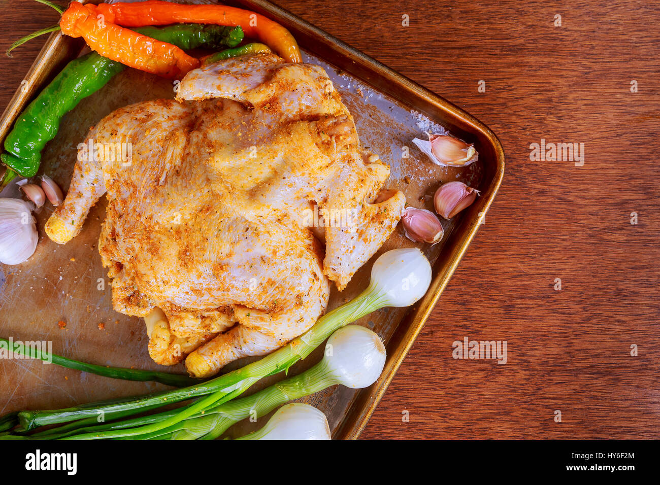 raw whole chicken marinated with garlic, thymeclose-up on the table ...