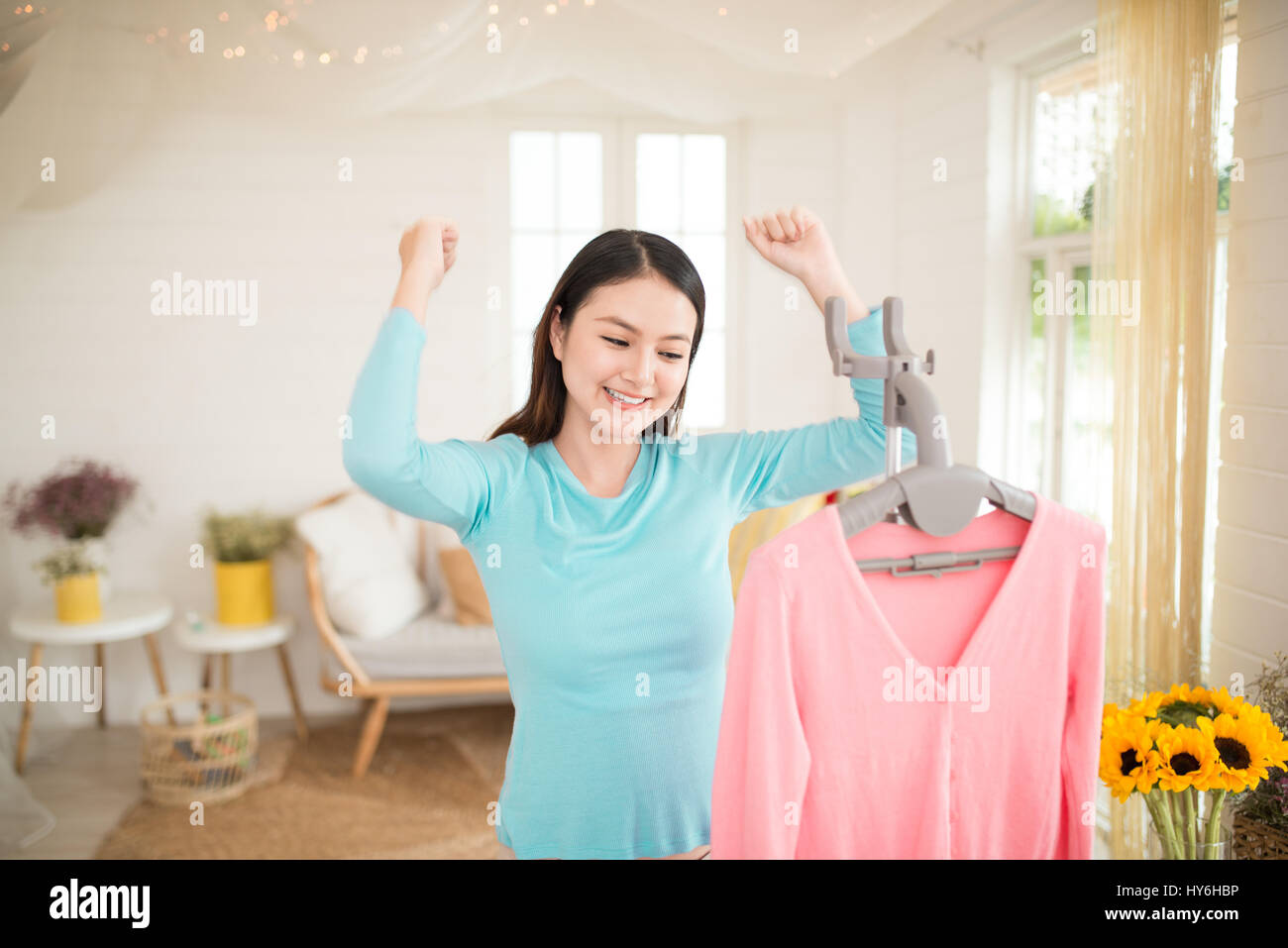 Happy young asian woman finish steaming clothes in room Stock Photo - Alamy