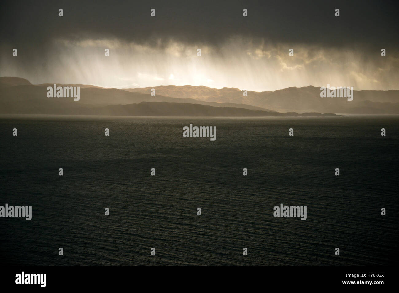 Dark rain clouds over a moody sea with hopeful sunshine breaking ...