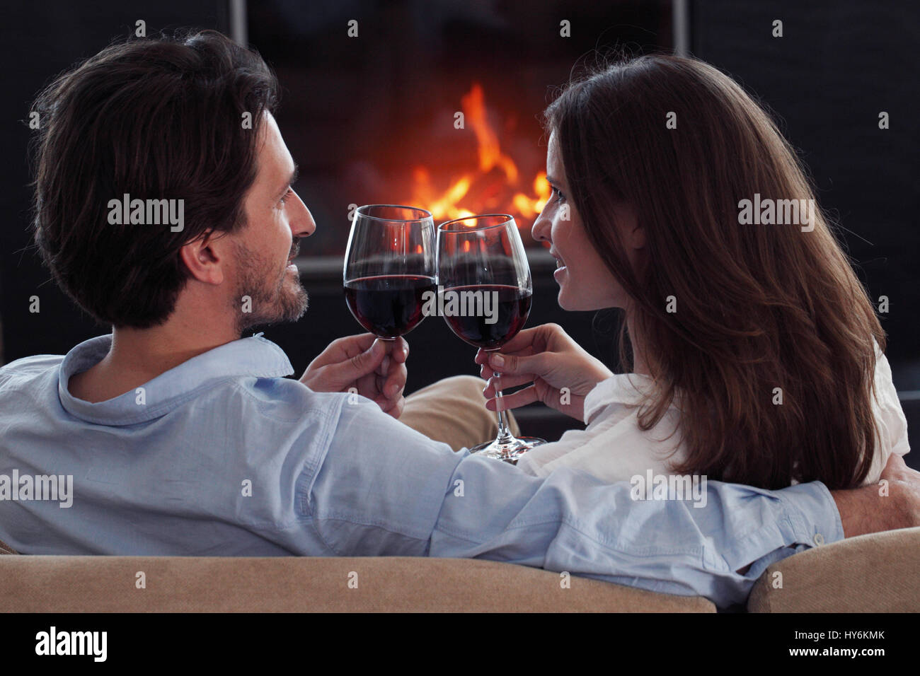 Romantic couple drinking wine at home near fireplace Stock Photo - Alamy