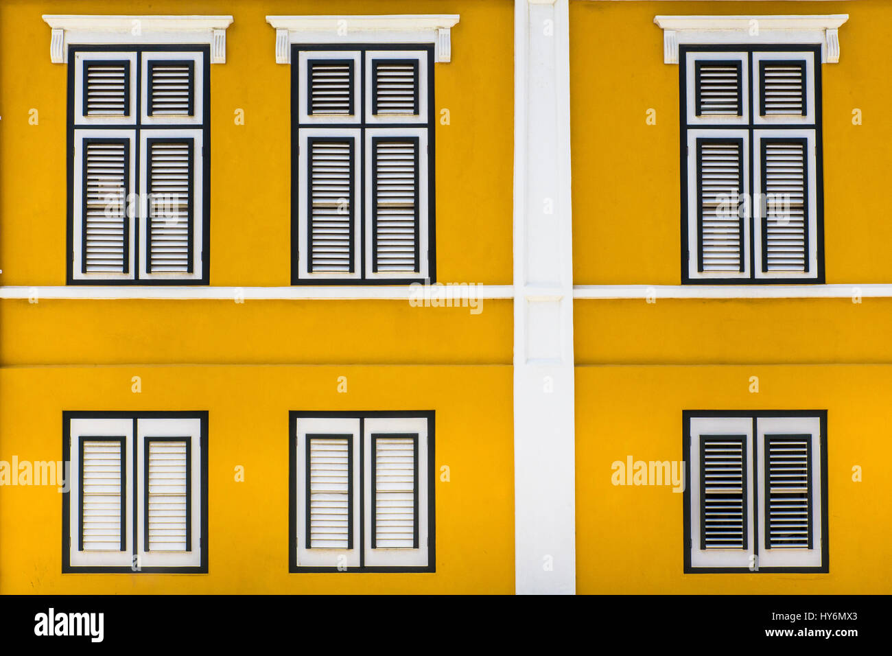 Vibrant yellow exterior building facade with windows Stock Photo - Alamy