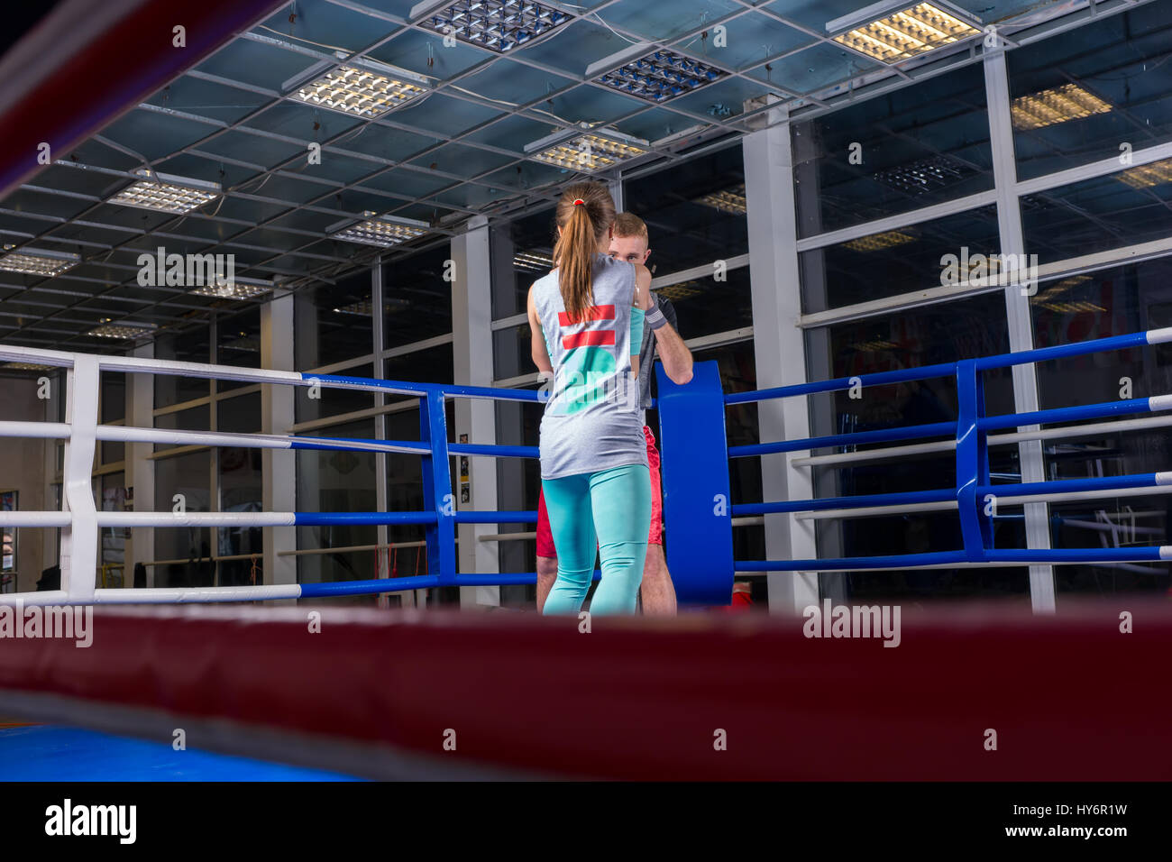 View through ropes of a regular boxing ring on young couple in ...