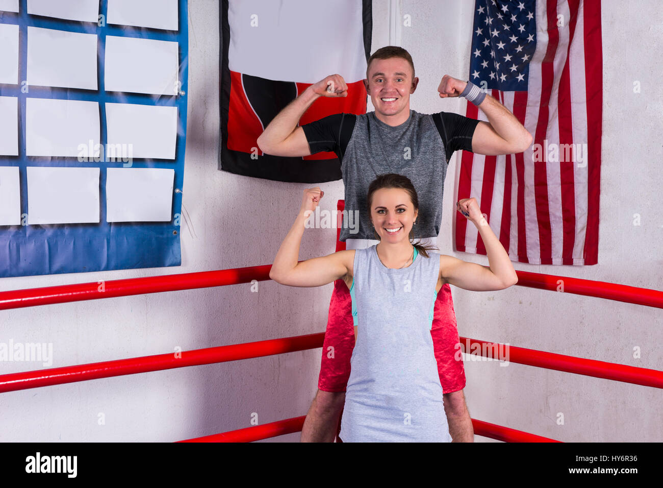 Couple in sportswear standing in a boxing pose in regular boxing ring ...