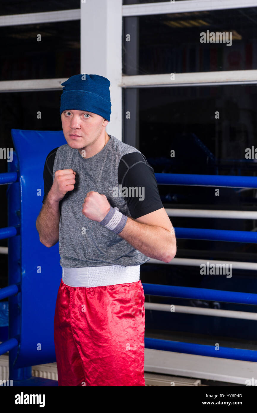 Athletic boxer standing in a pose clenching his fists in a regular ...