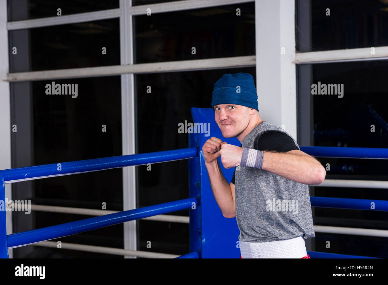 Athletic male boxer standing in a pose clenching his fists in a regular ...