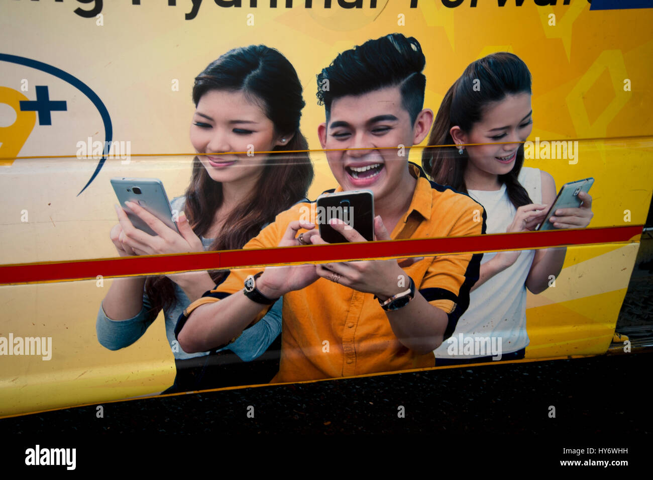 Myanmar (Burma). Yangon. Public bus painted with an advert for a mobile ...