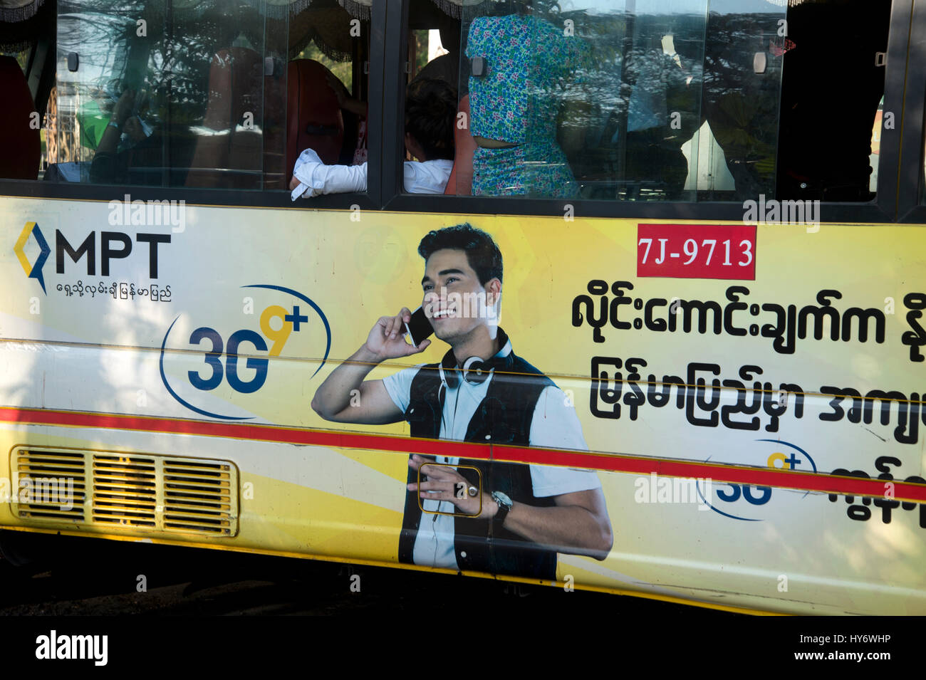 Myanmar (Burma). Yangon. Public bus painted with an advert for a mobile ...