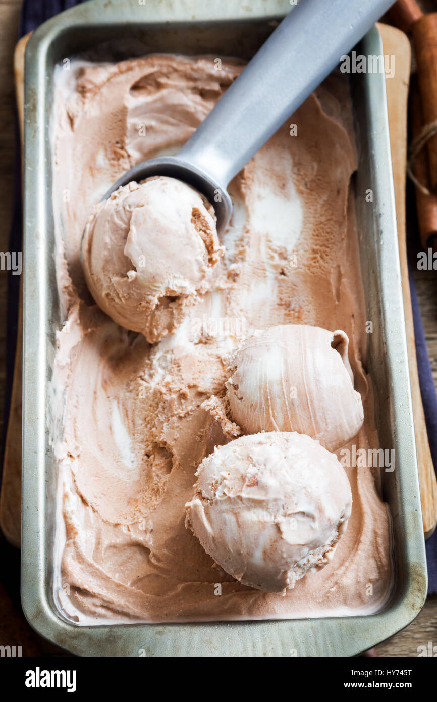 Homemade ice cream with scoop in frozen metallic container on wooden ...