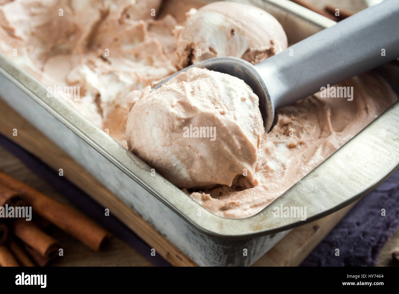 Homemade ice cream with scoop in frozen metallic container on wooden ...
