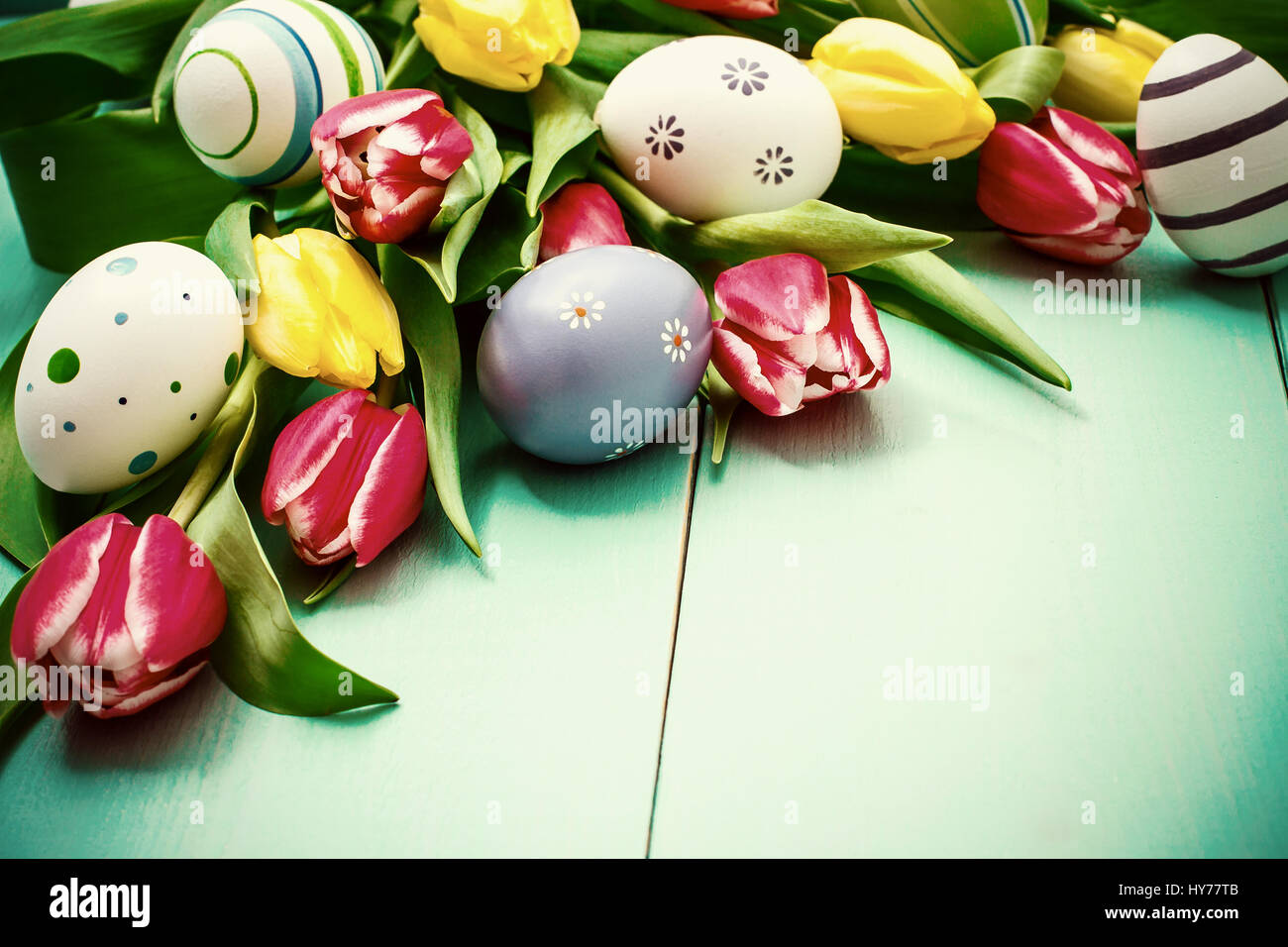 Red and yellow tulips with colorful Easter eggs Stock Photo - Alamy
