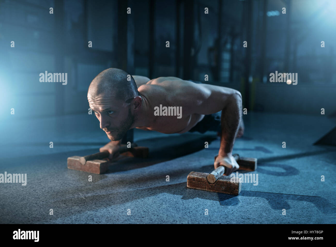 Healthy sportsman makes pushups exercises on training. Strong gymnast ...