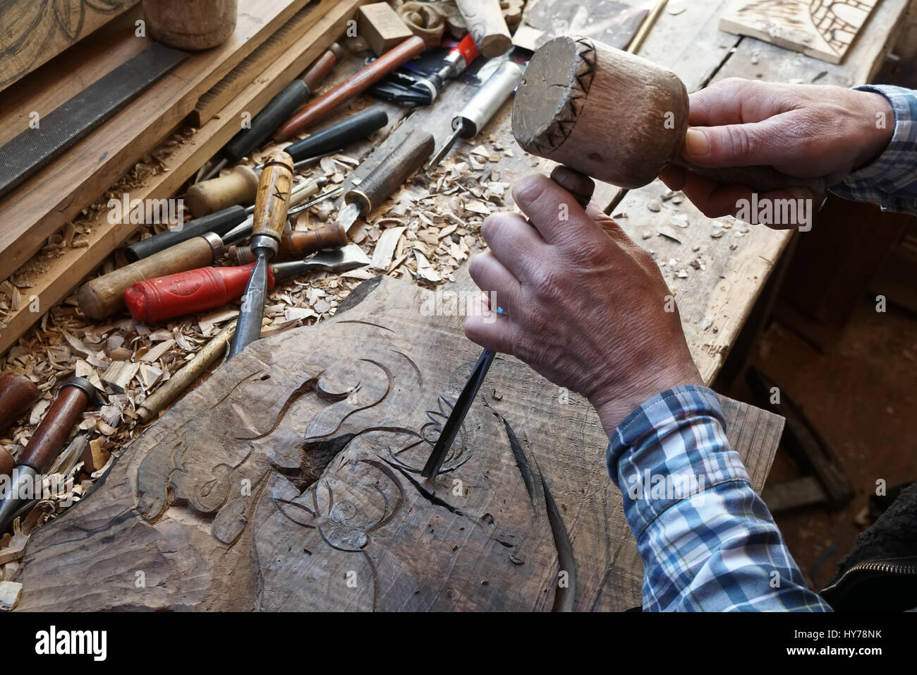 Wood carving. Carver with chisel and hammer. A skillful craftsman ...