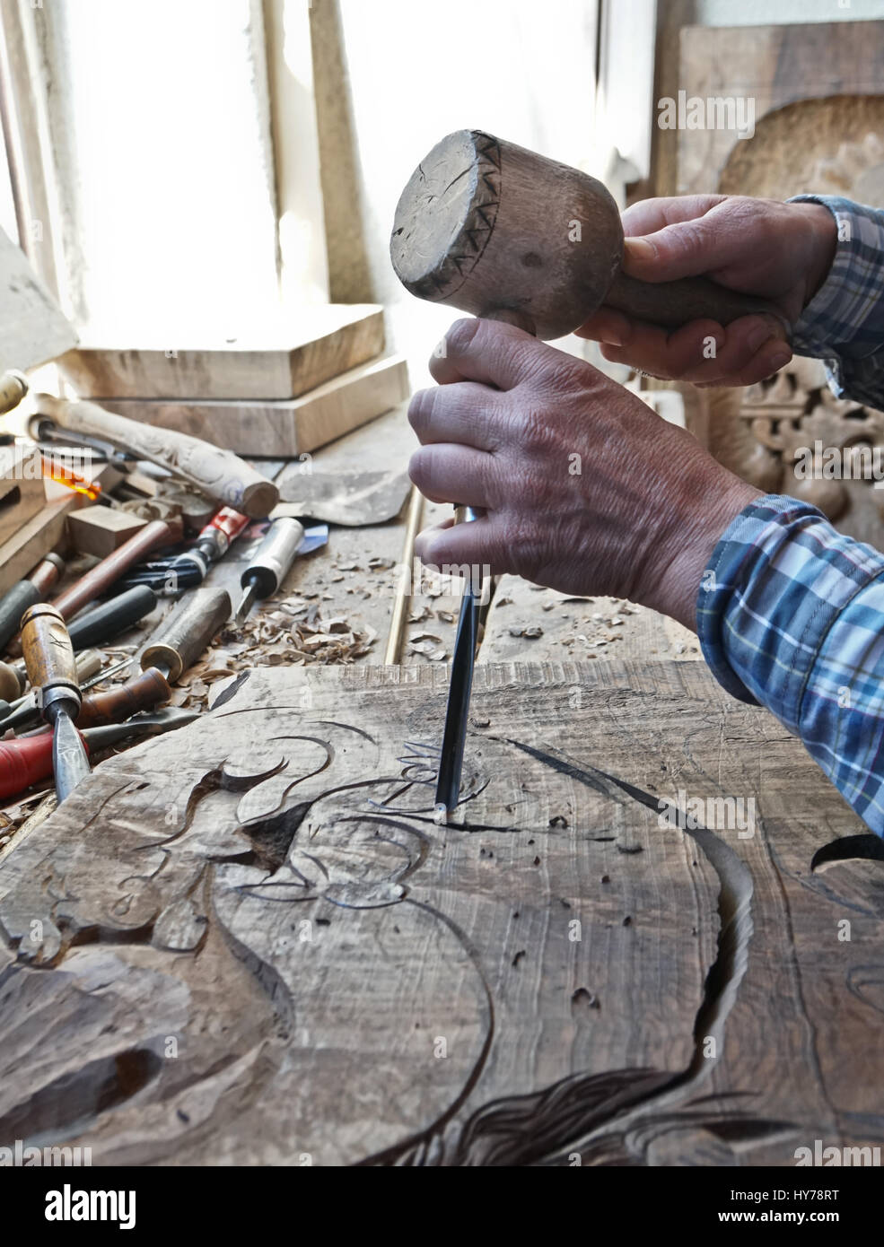 Wood carving. Carver with chisel and hammer. A skillful craftsman ...