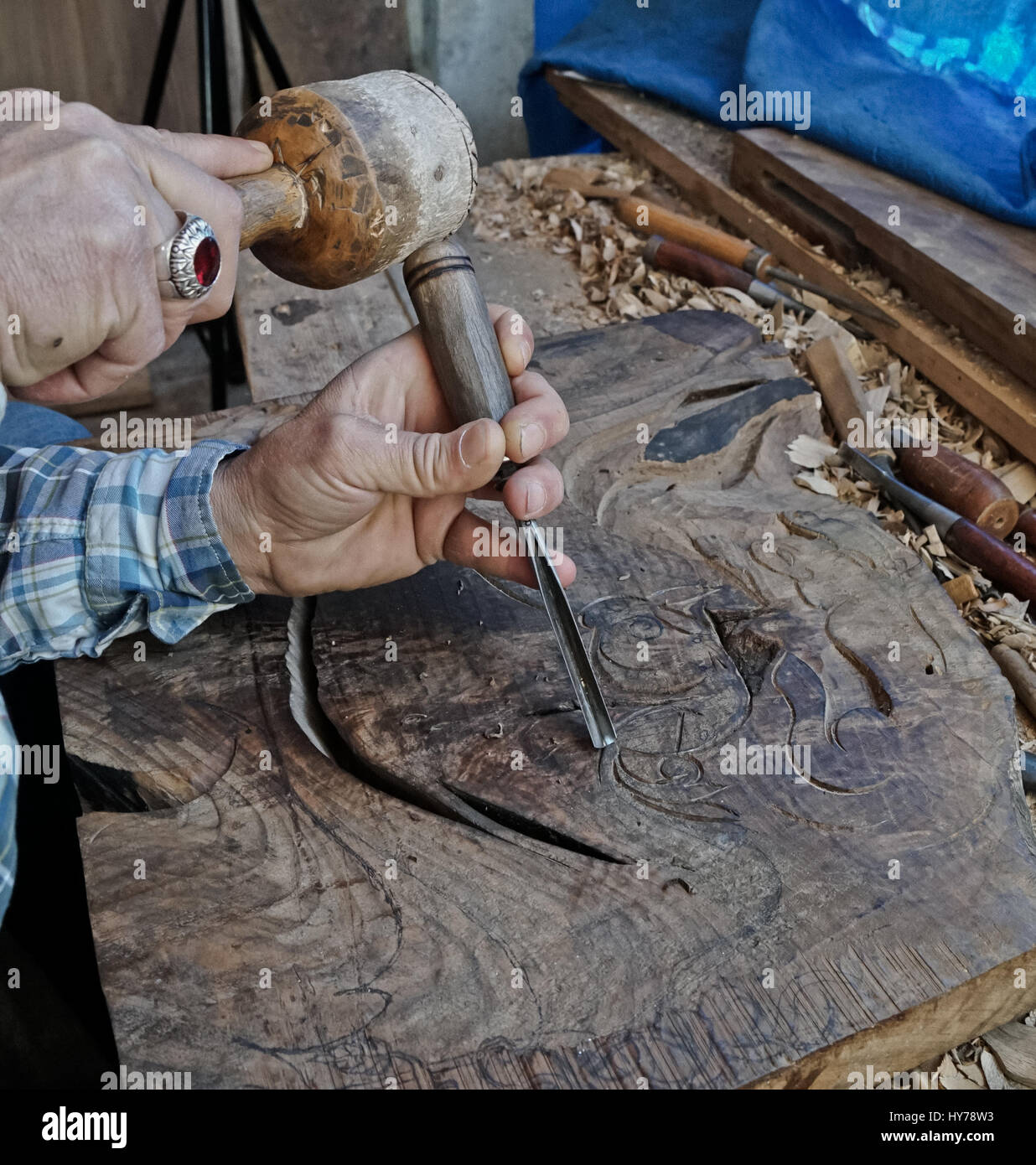 Wood carving. Carver with chisel and hammer. A skillful craftsman ...