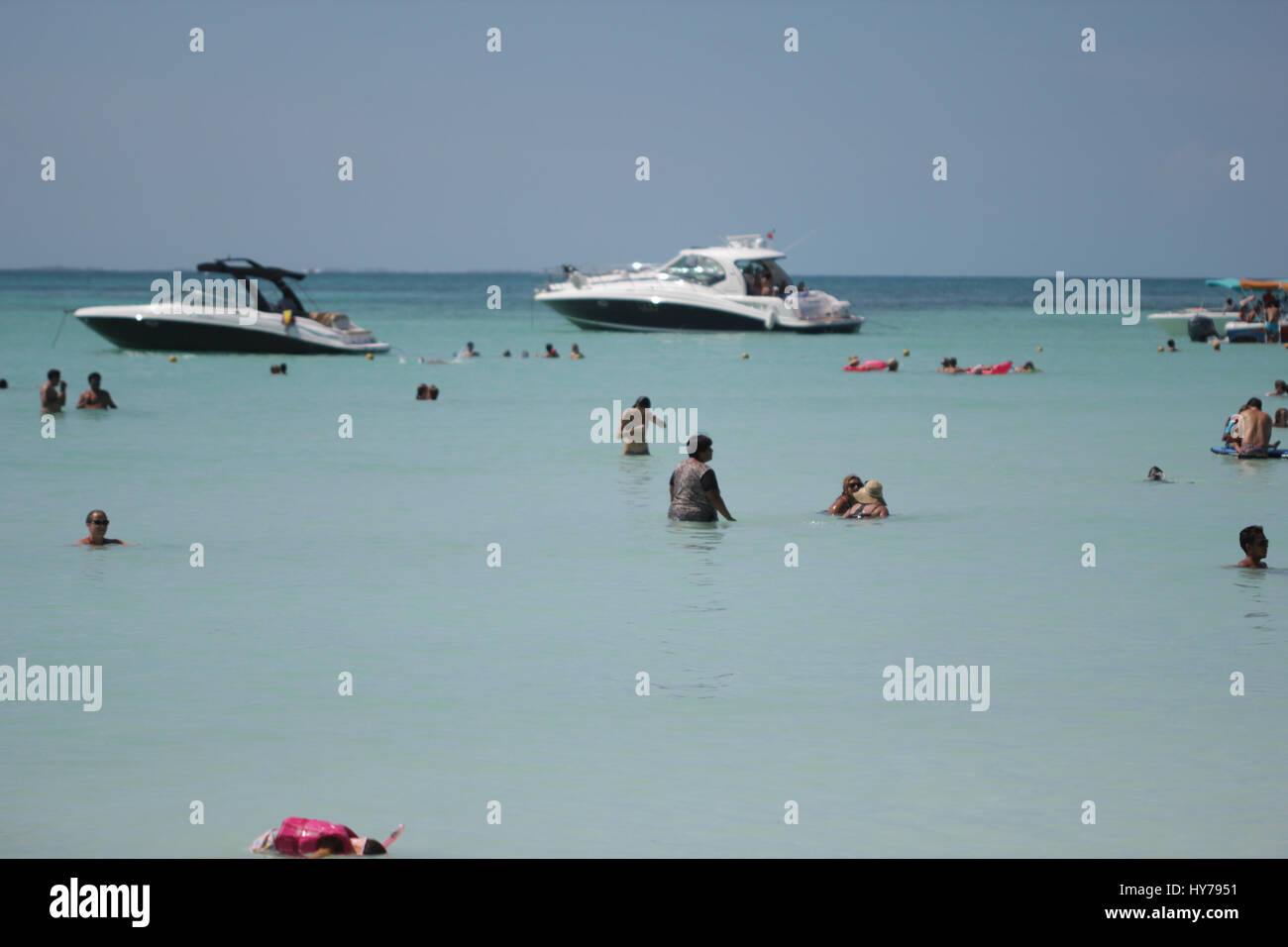 Boats and people swimming in Caribbean Sea at Isla Mujeres island ...