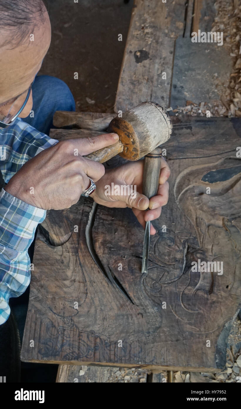 Wood carving. Carver with chisel and hammer. A skillful craftsman ...