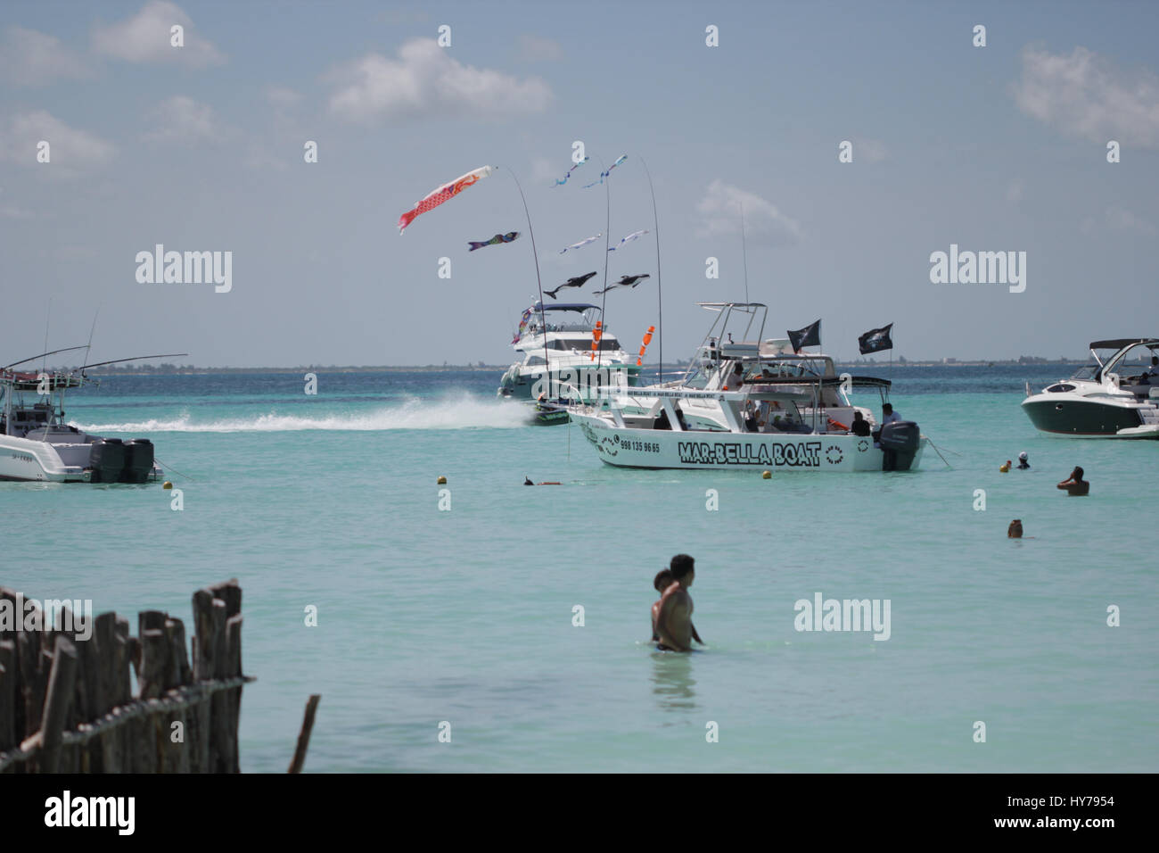 Boats and people swimming in Caribbean Sea at Isla Mujeres island ...