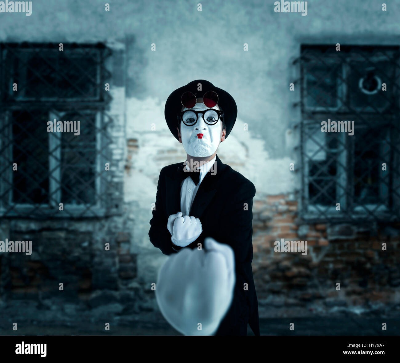 Pantomime actor in glasses shows boxer. Mime in suit, gloves and hat ...
