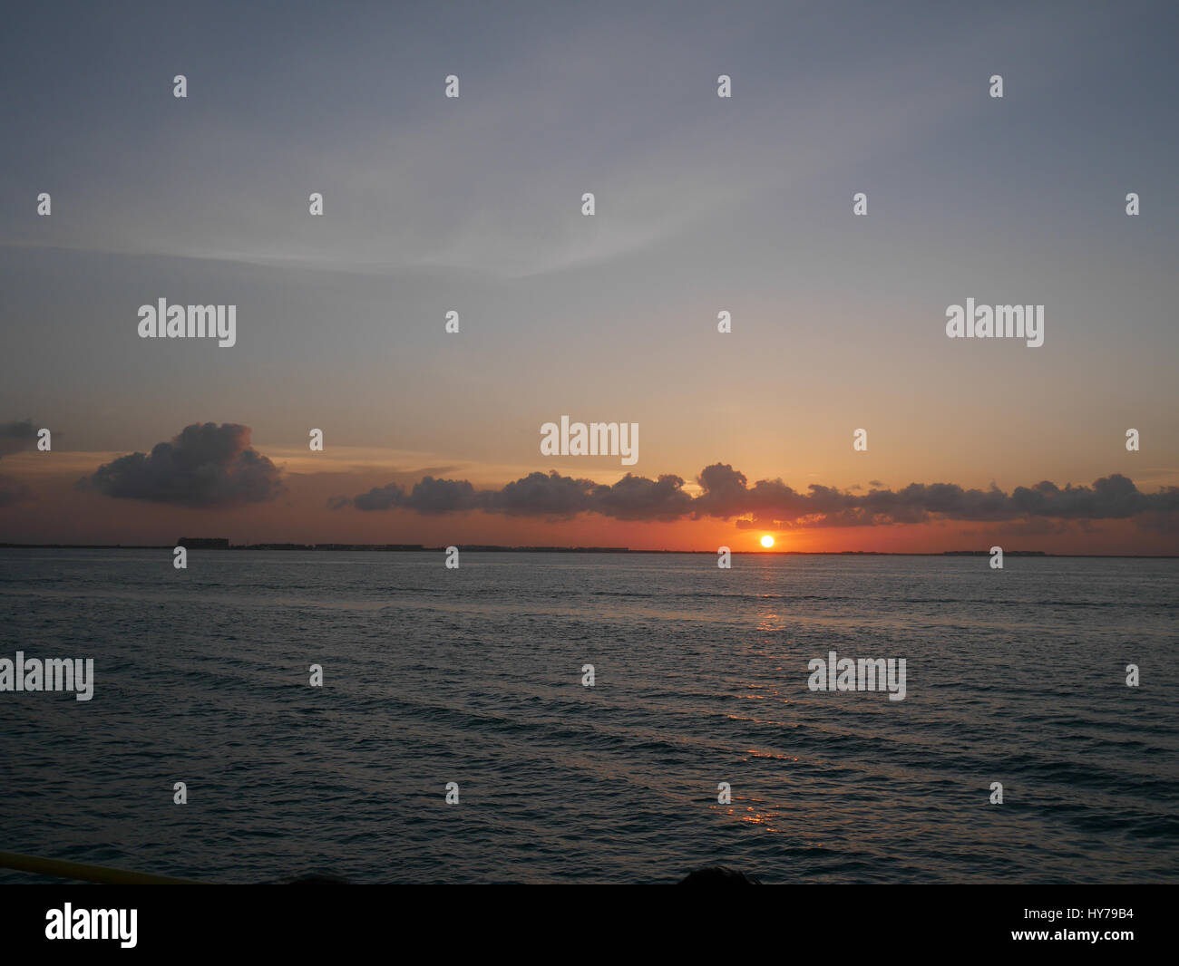 Sun getting down to water, red sky Stock Photo - Alamy
