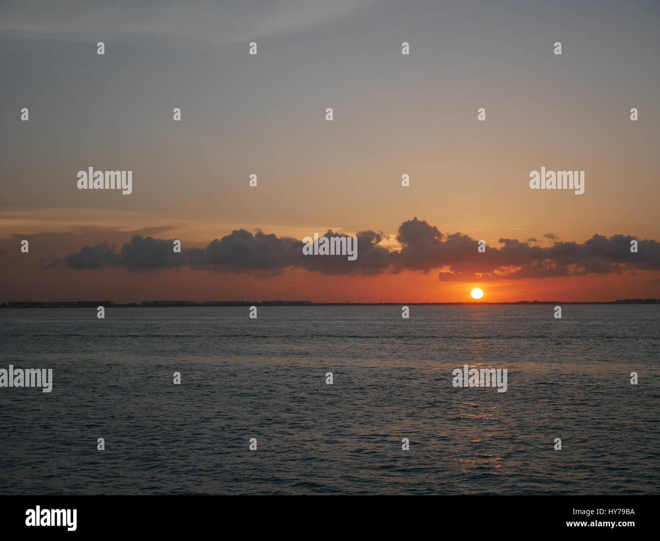 Sun getting down to water, red sky Stock Photo - Alamy