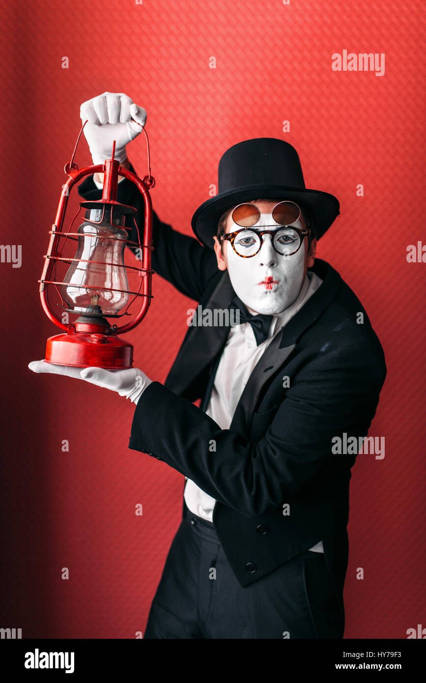 Pantomime actor performing with kerosene lantern. Comedy mime artist in ...