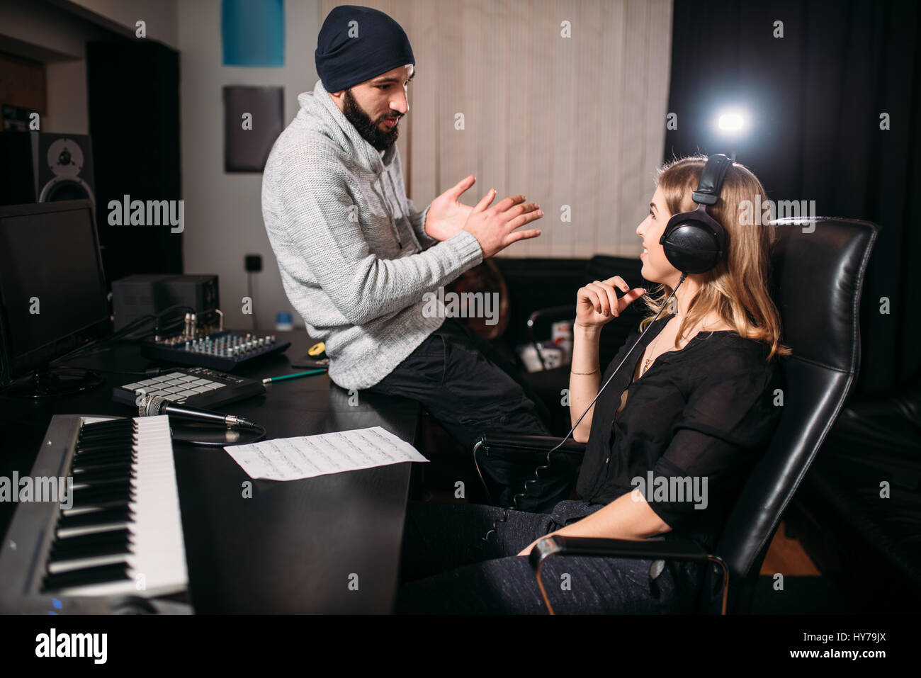 Sound producer work with female singer in headphones, song record in ...
