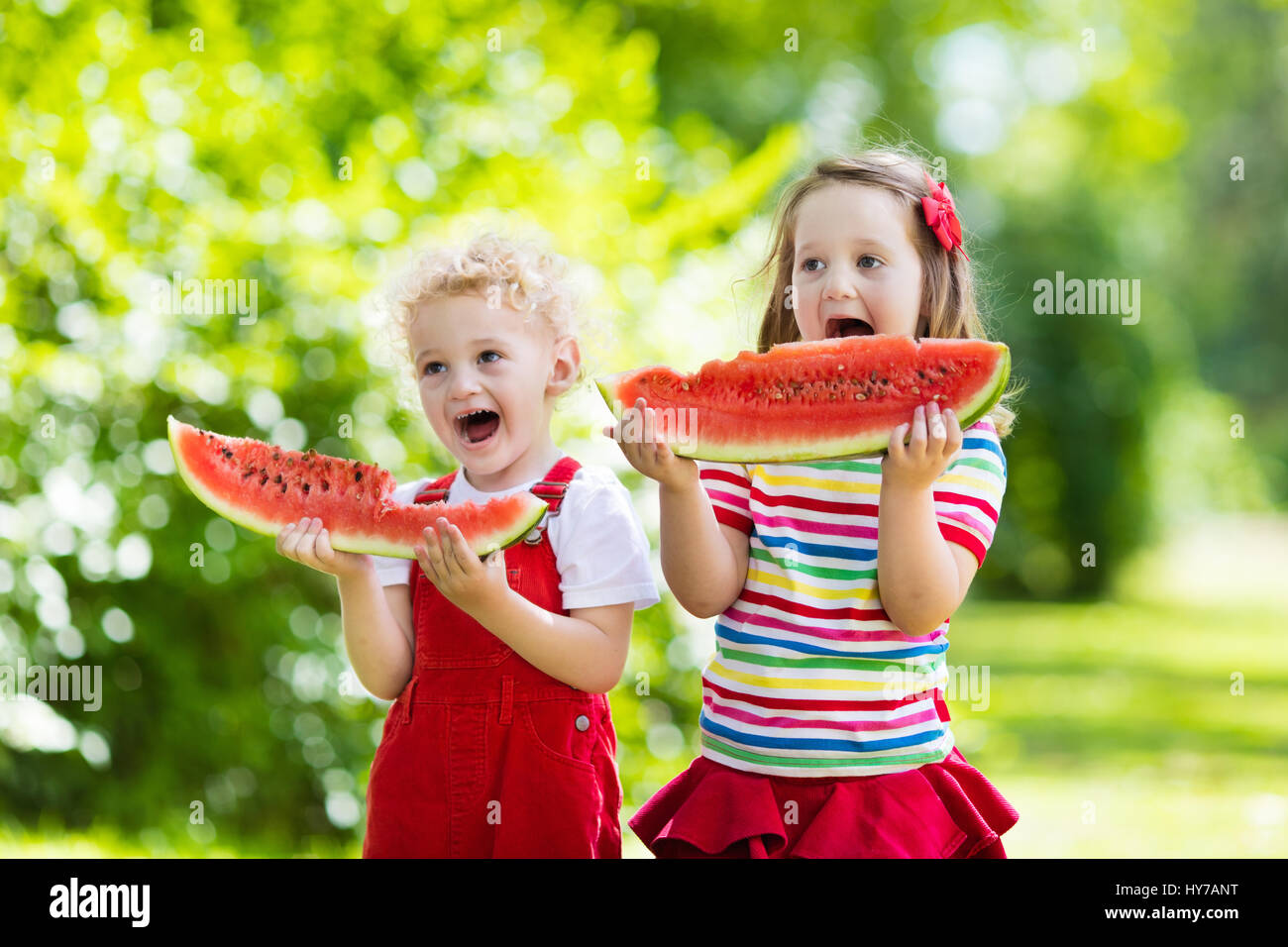 Child eating watermelon in the garden. Kids eat fruit outdoors. Healthy ...