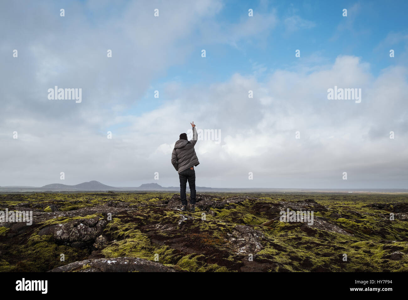 Landscaped, rear view a man rise hand up show V sign on hand Stock ...
