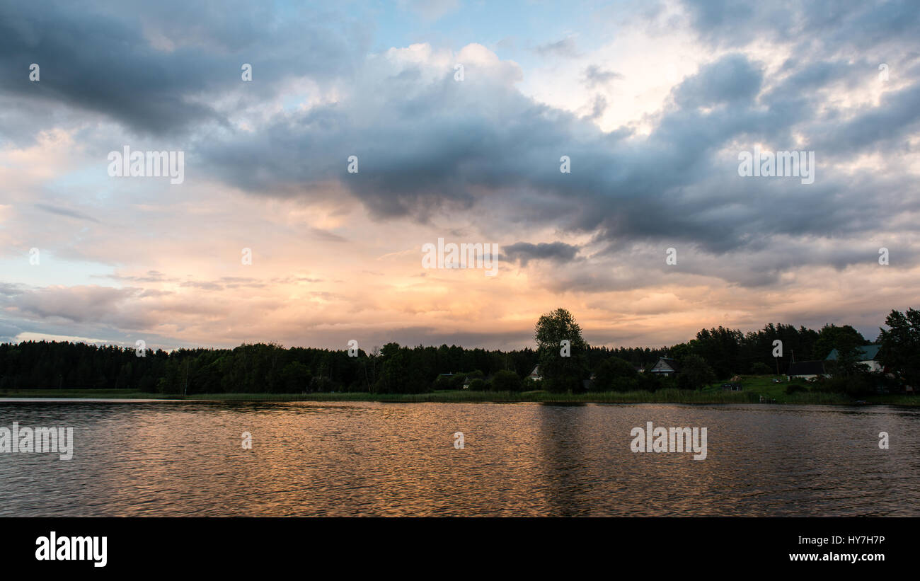 Beautiful summer sunset at the river with blue sky, red and orange ...