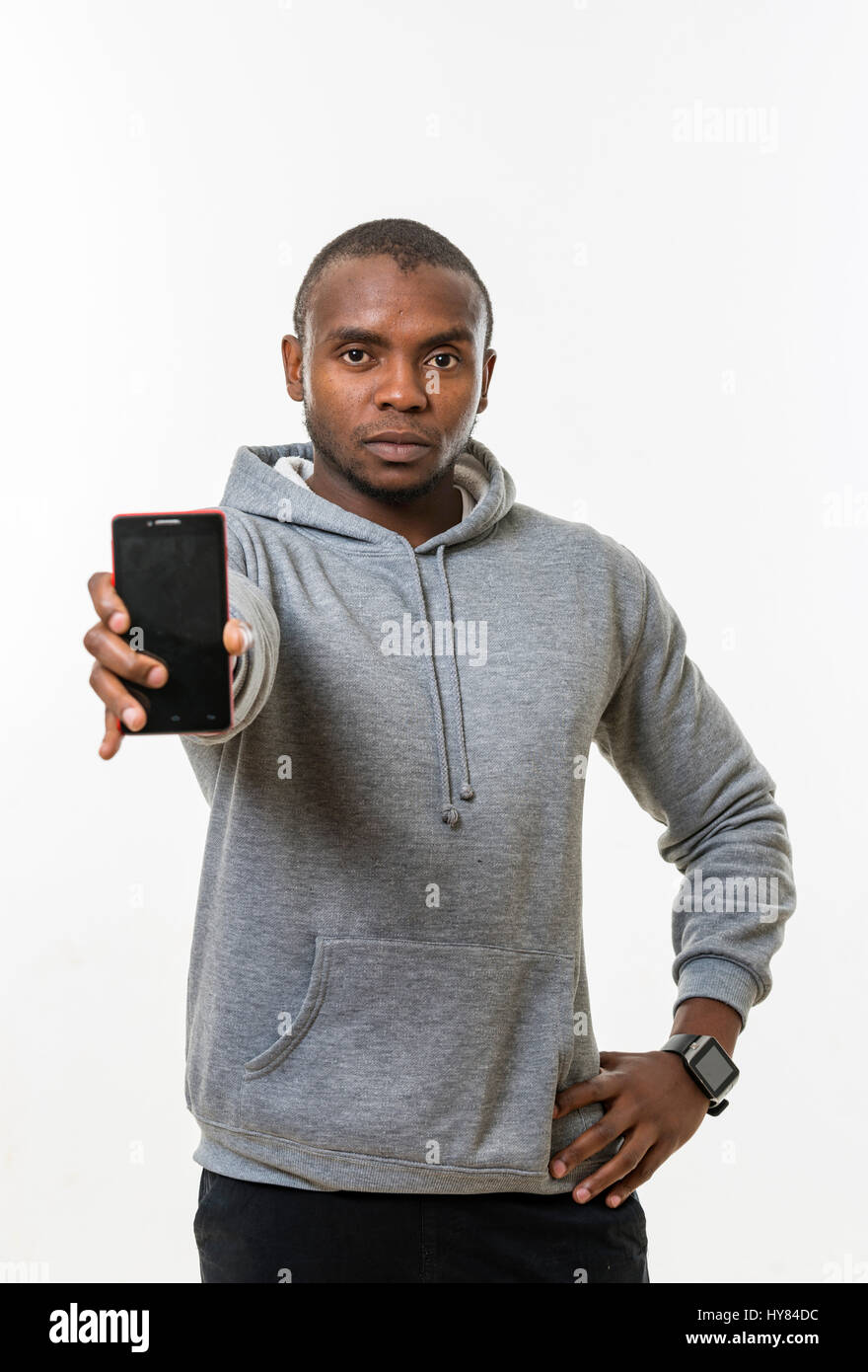 An African man uses a cellphone in a studio environment Stock Photo - Alamy
