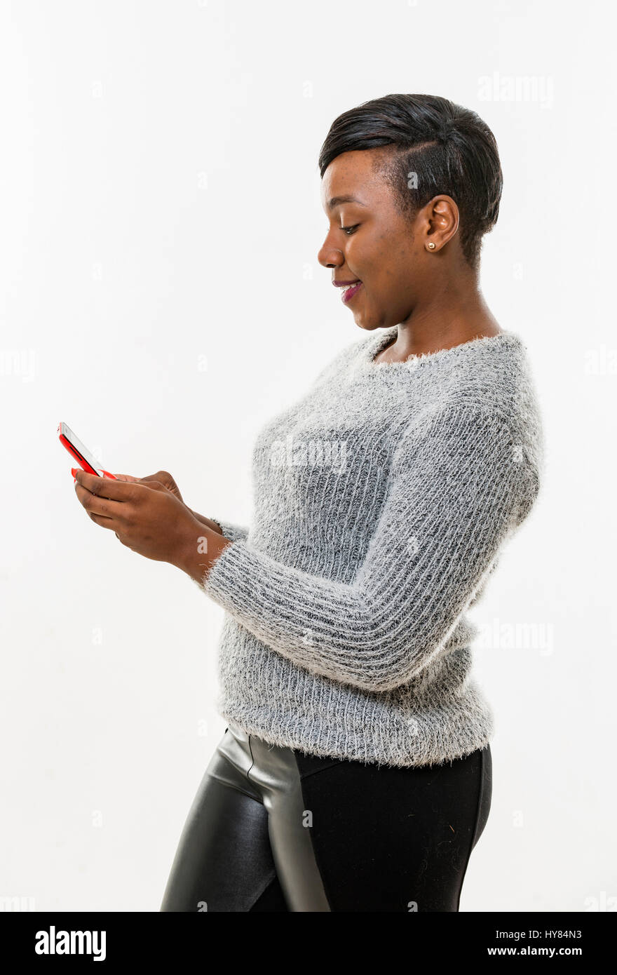 An African woman uses a mobile device in a studio setting Stock Photo ...