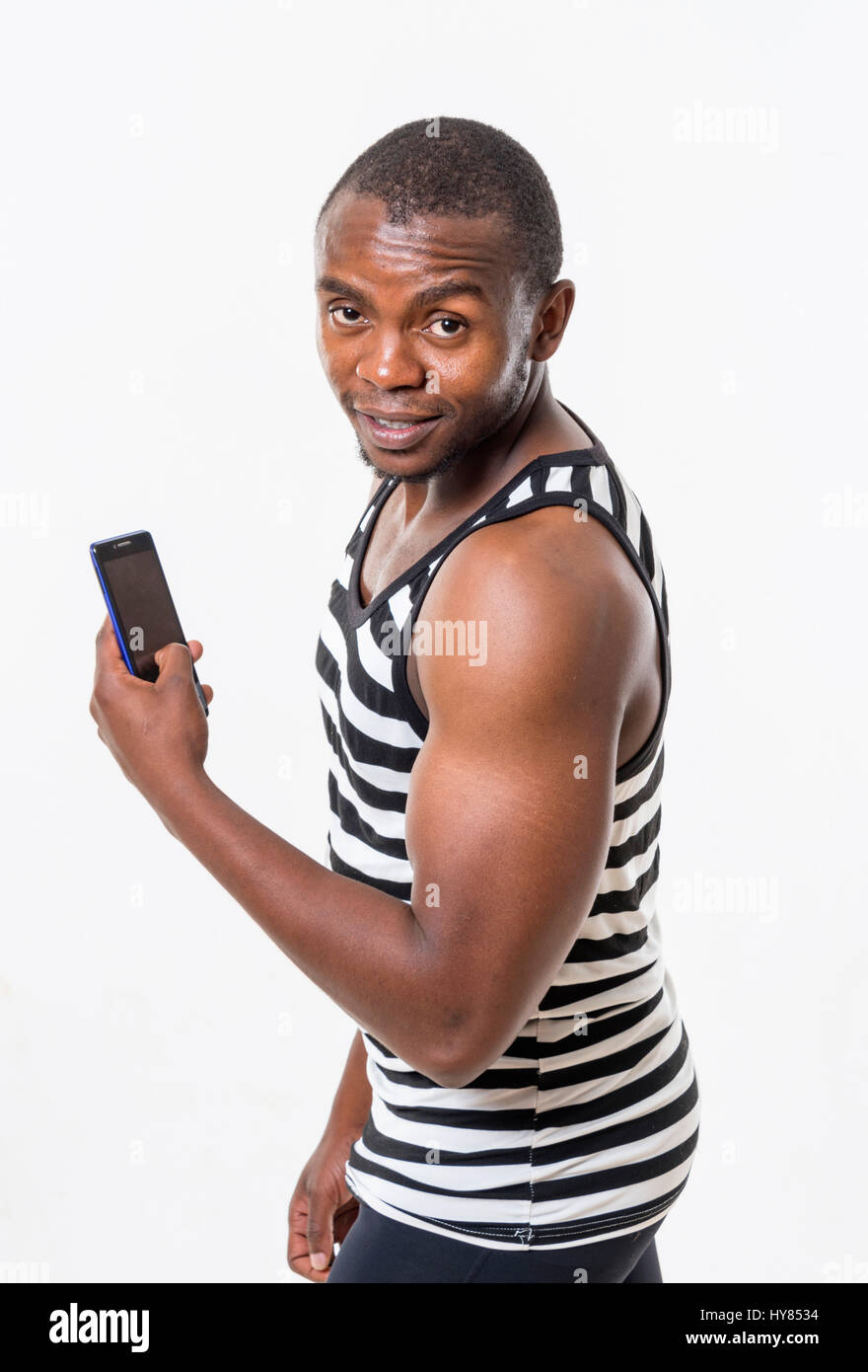 An African man uses a cellphone in a studio environment Stock Photo - Alamy