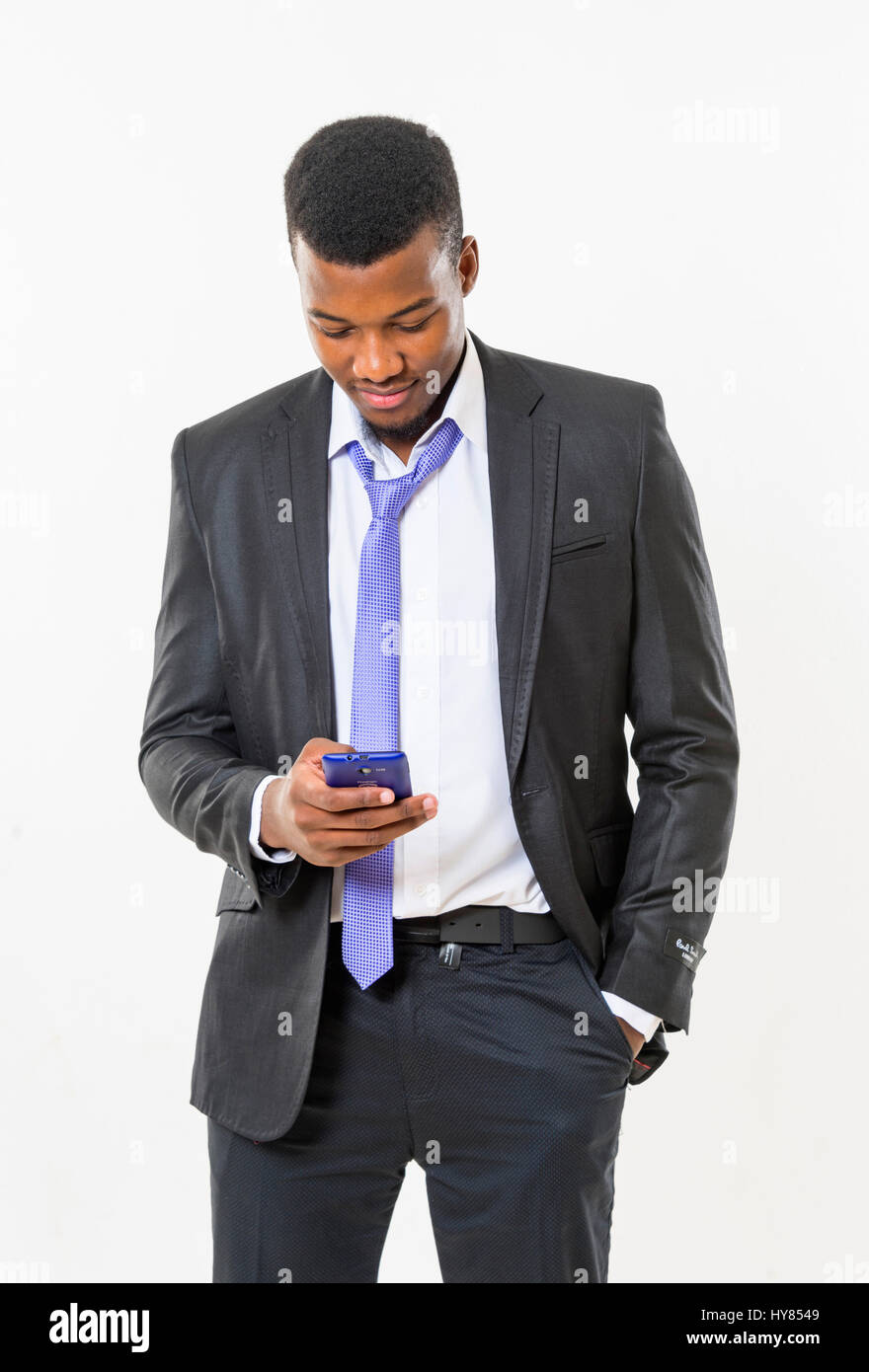 An African man using a mbile device in a studio setting Stock Photo - Alamy