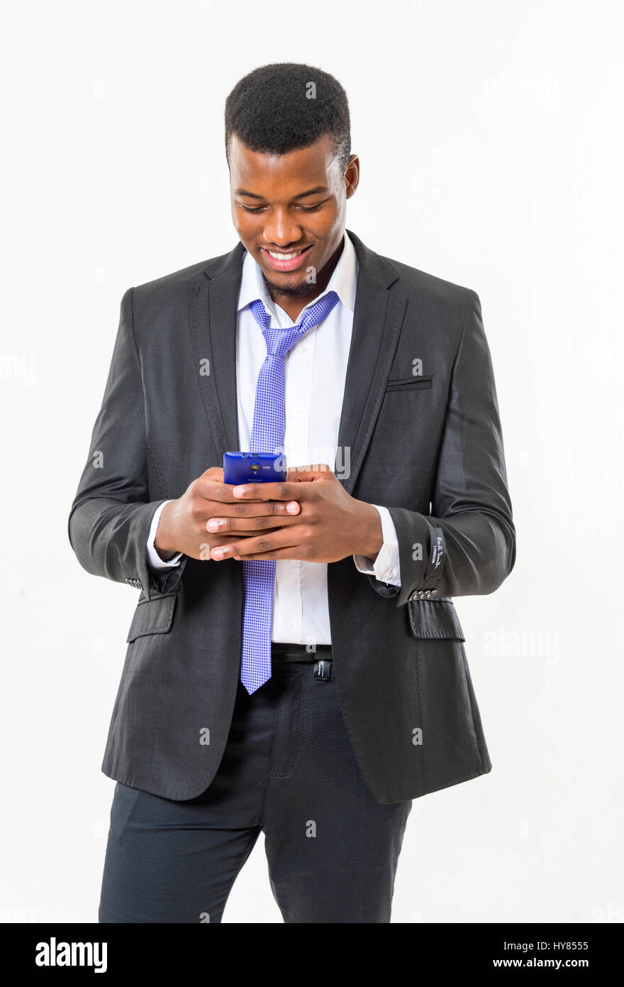 An African man using a mbile device in a studio setting Stock Photo - Alamy