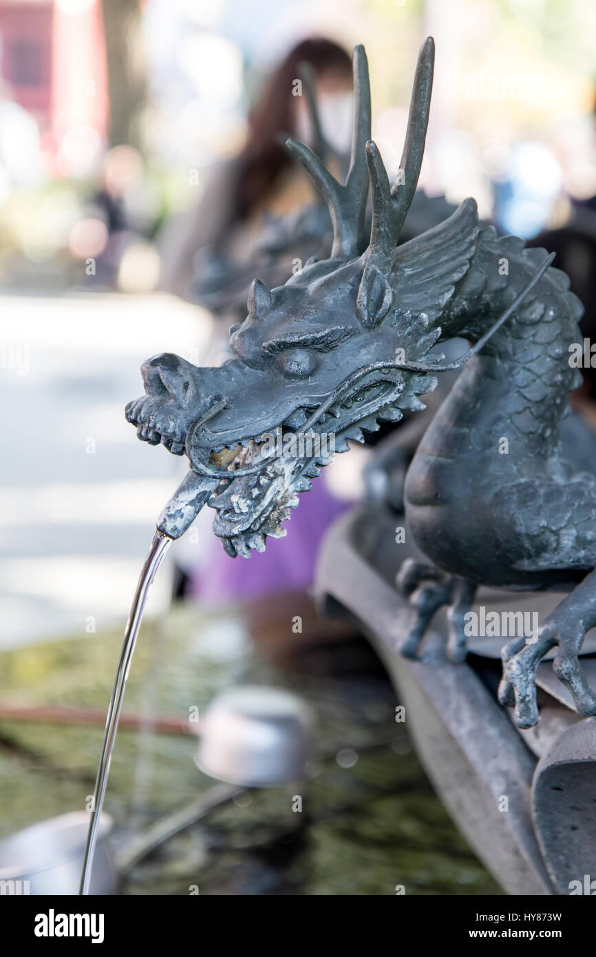 Metal dragon spewing water in the well in the Senso-ji temple, Tokyo ...