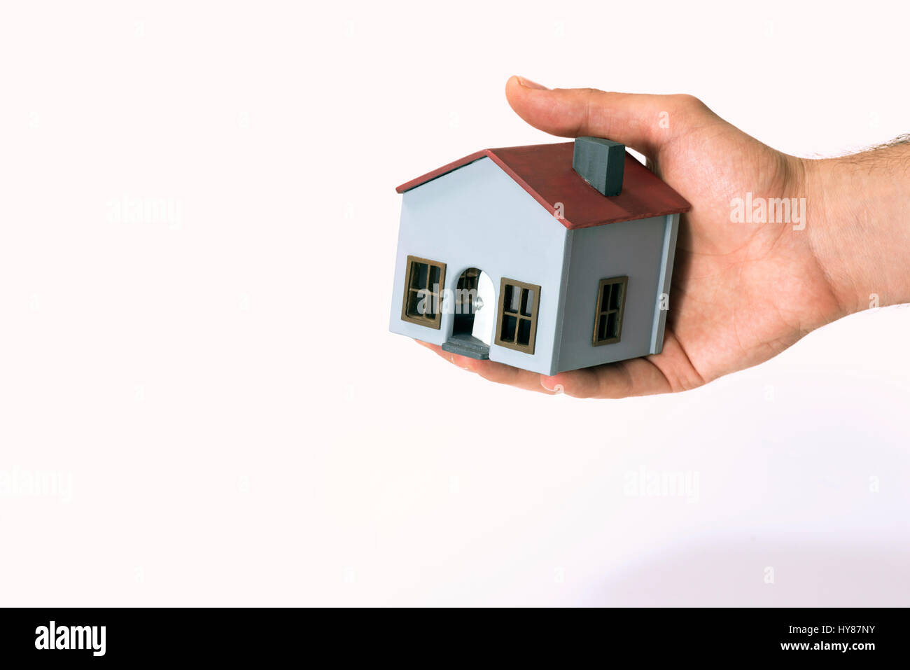 Model house on a white background with hand Stock Photo - Alamy