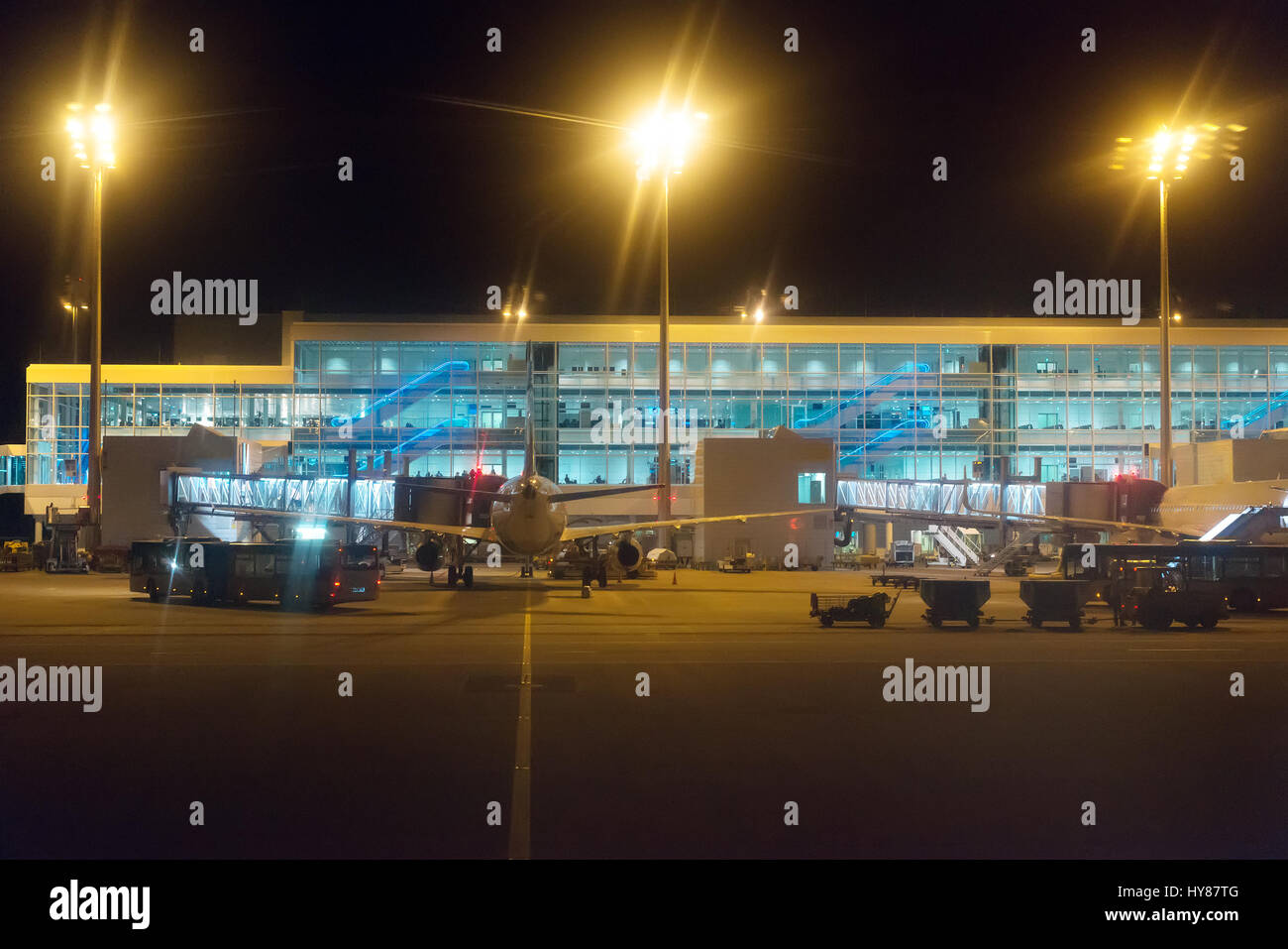 Passenger plane and busses at night airport Stock Photo - Alamy