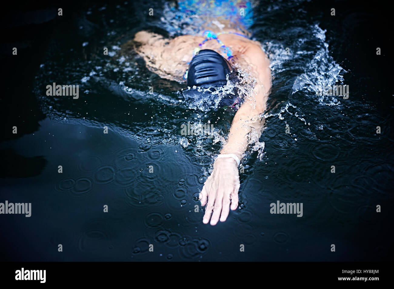 Happy confident young female swimmer in an outside pool in southern ...
