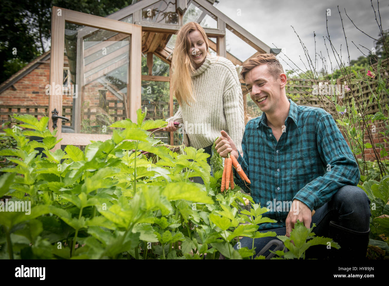 Two young gardeners work in their vegetable garden Stock Photo - Alamy