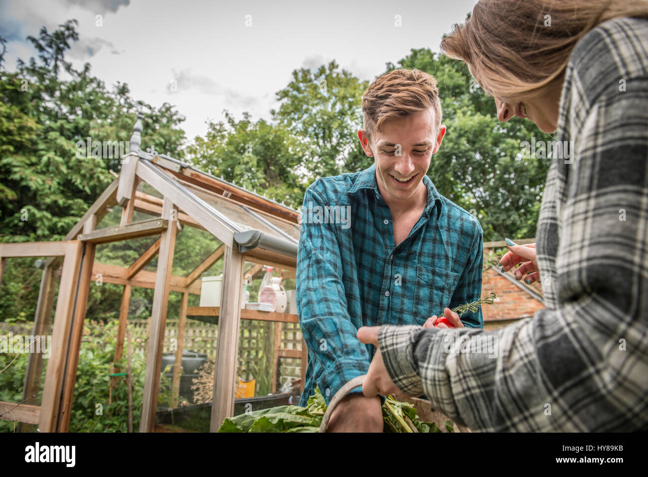 Two young gardeners work in their vegetable garden Stock Photo - Alamy