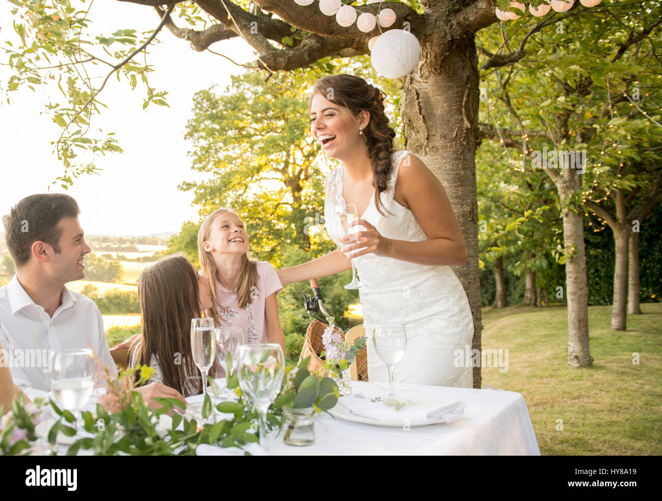 A bride and groom sitting at the top table with their friends at an ...