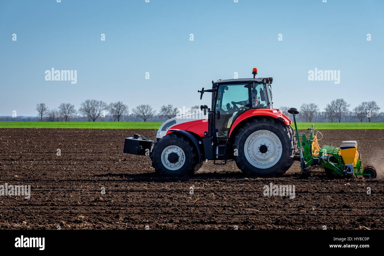 Agriculture tractor sowing seeds and cultivating field Stock Photo - Alamy