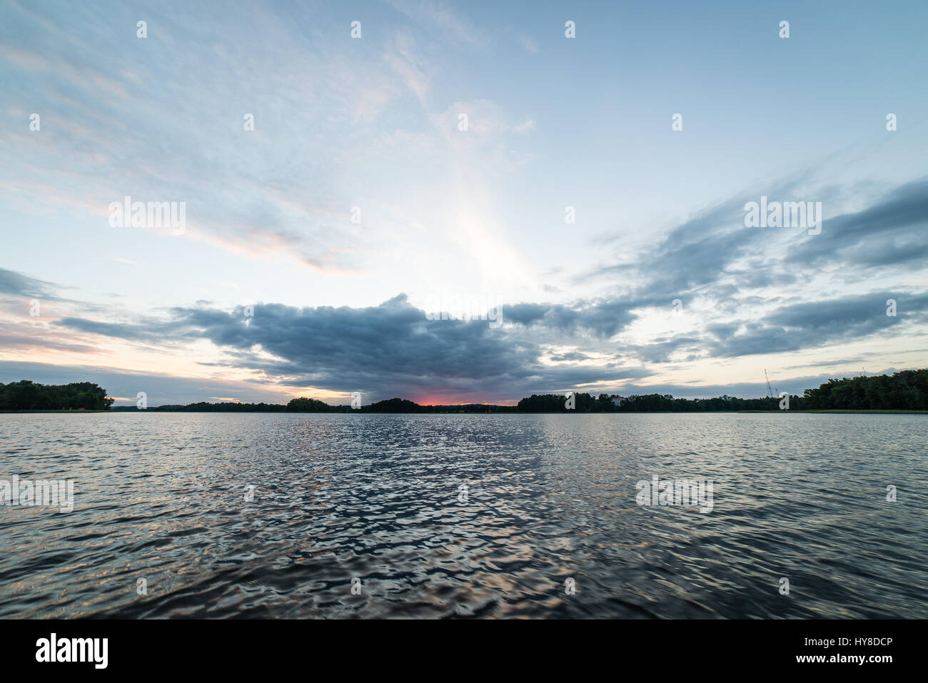 Beautiful summer sunset at the river with blue sky, red and orange ...