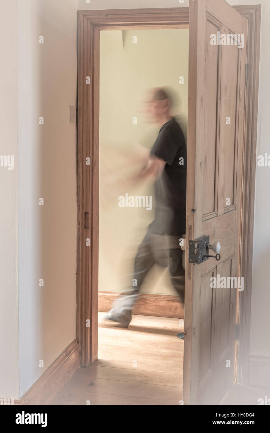 Man walking past door inside house Stock Photo - Alamy