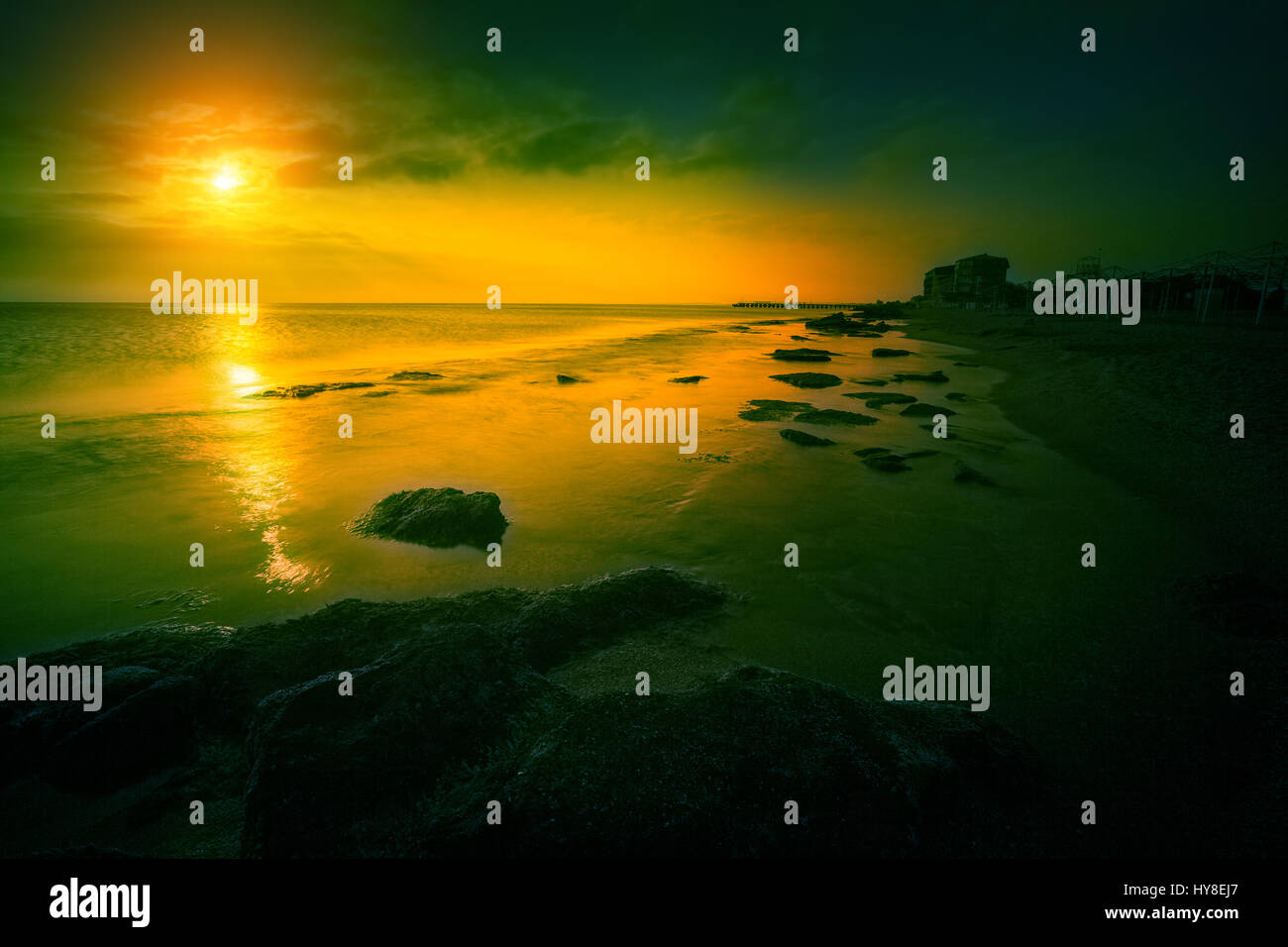 Early morning, sunrise over sea. Rocky sea shore Stock Photo - Alamy
